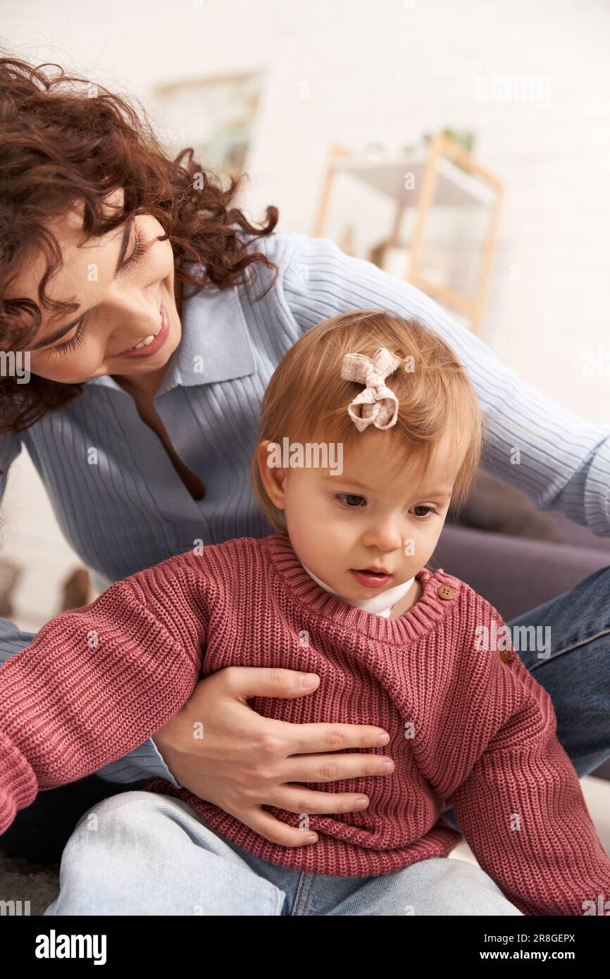 multitasking woman, engaging with child, balancing between work and ...
