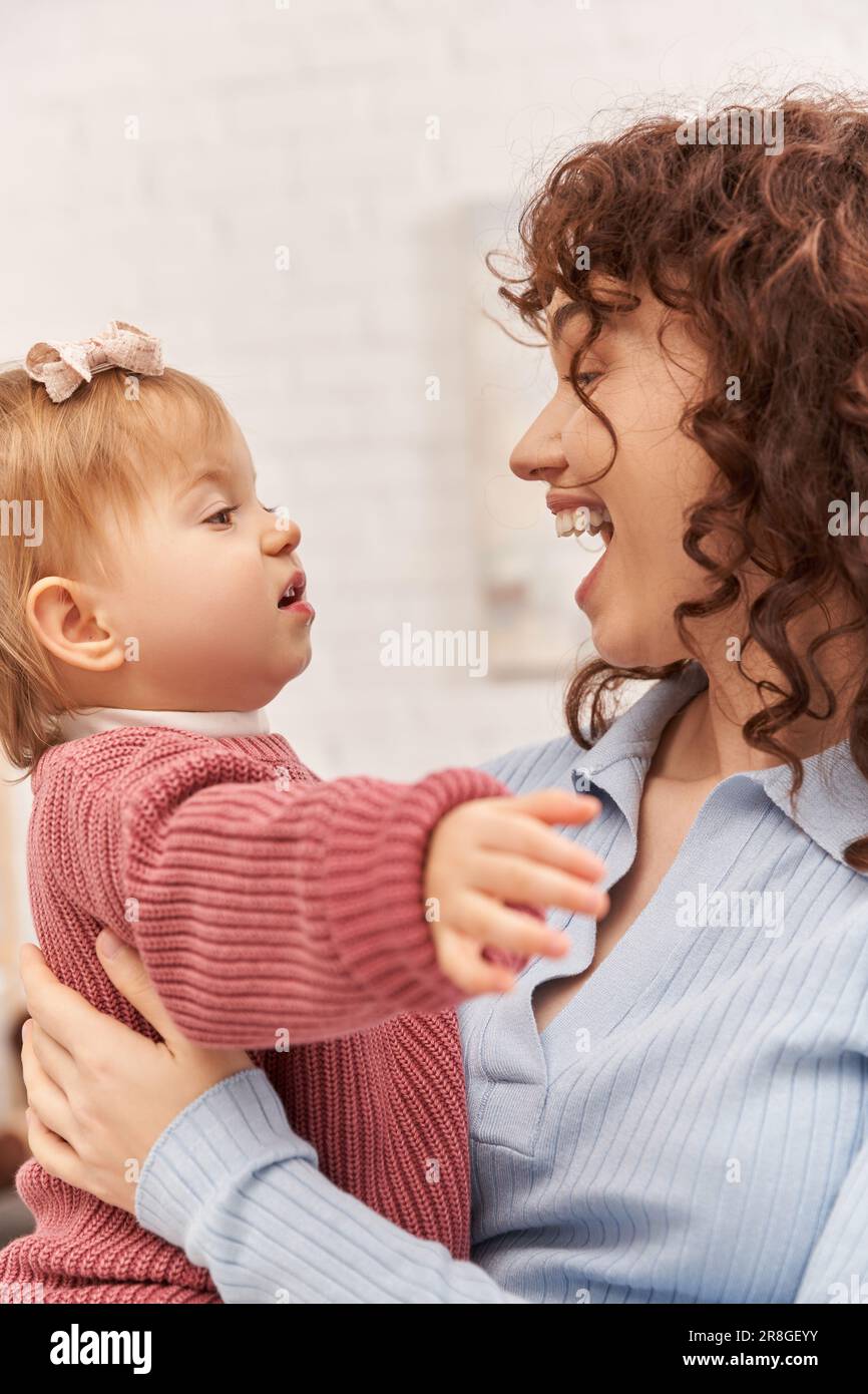 balanced lifestyle, working mother with curly hair holding in arms baby ... balanced lifestyle, working mother with curly hair holding in arms baby ...