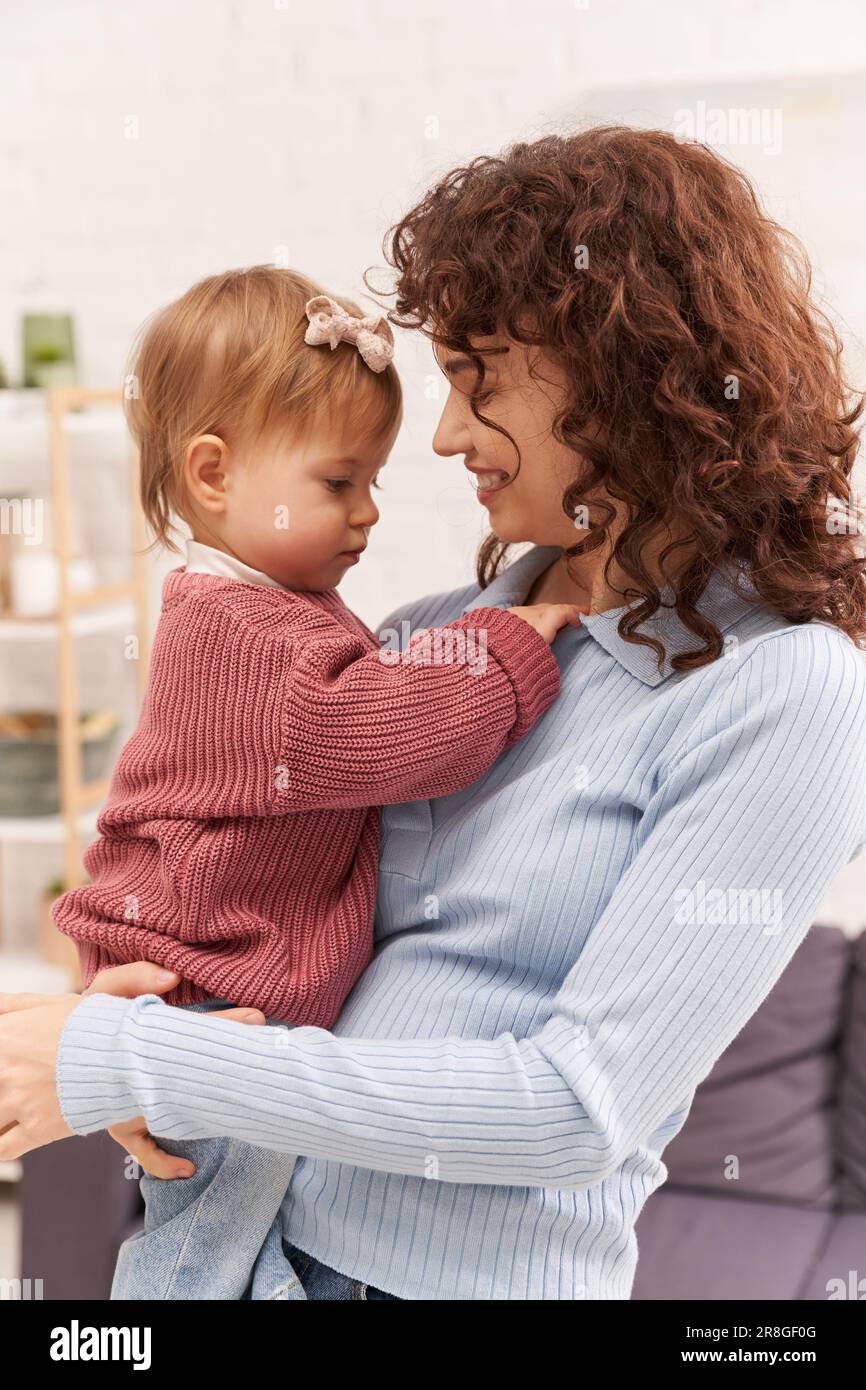 balanced lifestyle, working mother with curly hair holding in arms baby ... balanced lifestyle, working mother with curly hair holding in arms baby ...