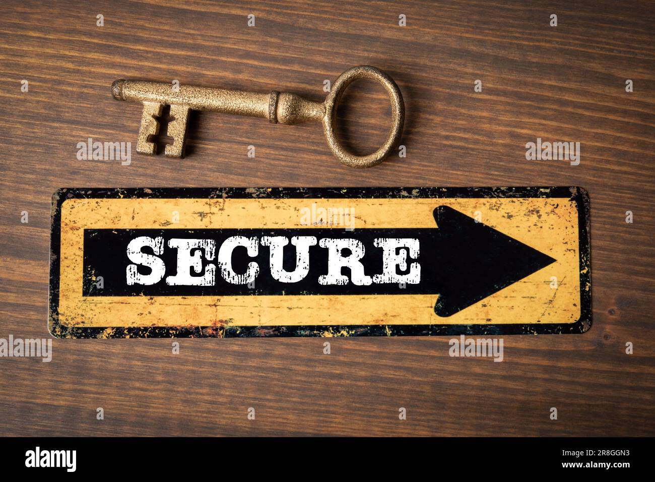 SECURE Concept. Direction arrow with text and golden key on wood ...