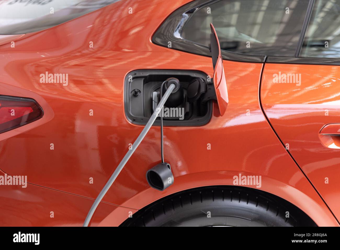 Orange electro car on charging at the station. Mid shot Stock Photo - Alamy
