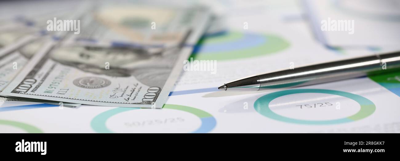 US dollar banknotes on chart with pen on desktop Stock Photo - Alamy