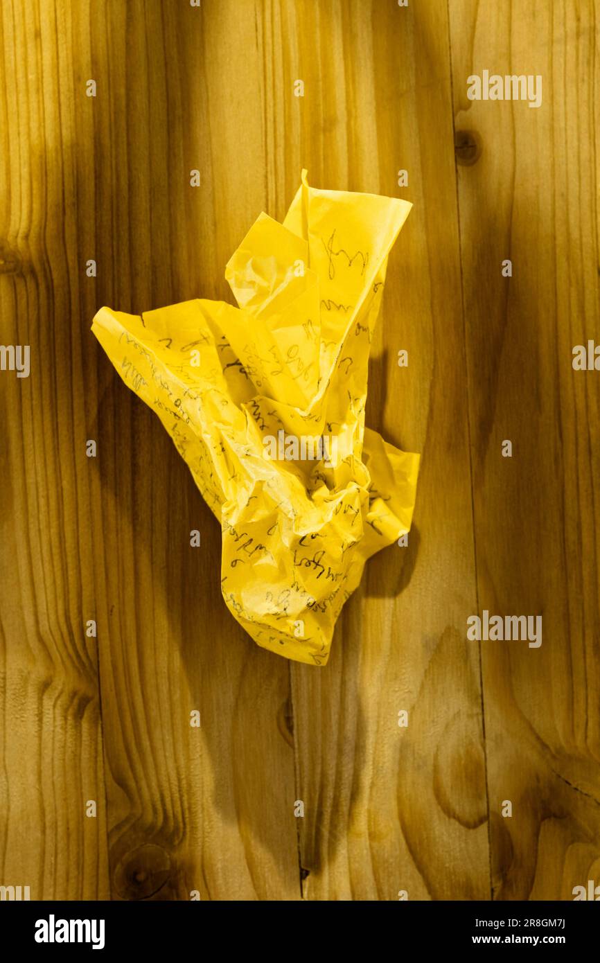 Sheet of yellow crumpled paper on wooden background , handwritten note ...