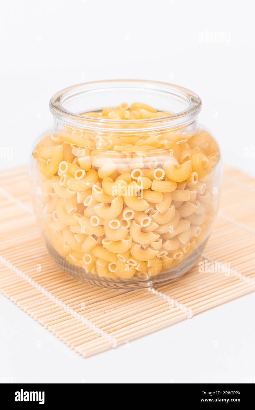 Uncooked Chifferi Rigati Pasta in Glass Jar on Bamboo Mat on White ...