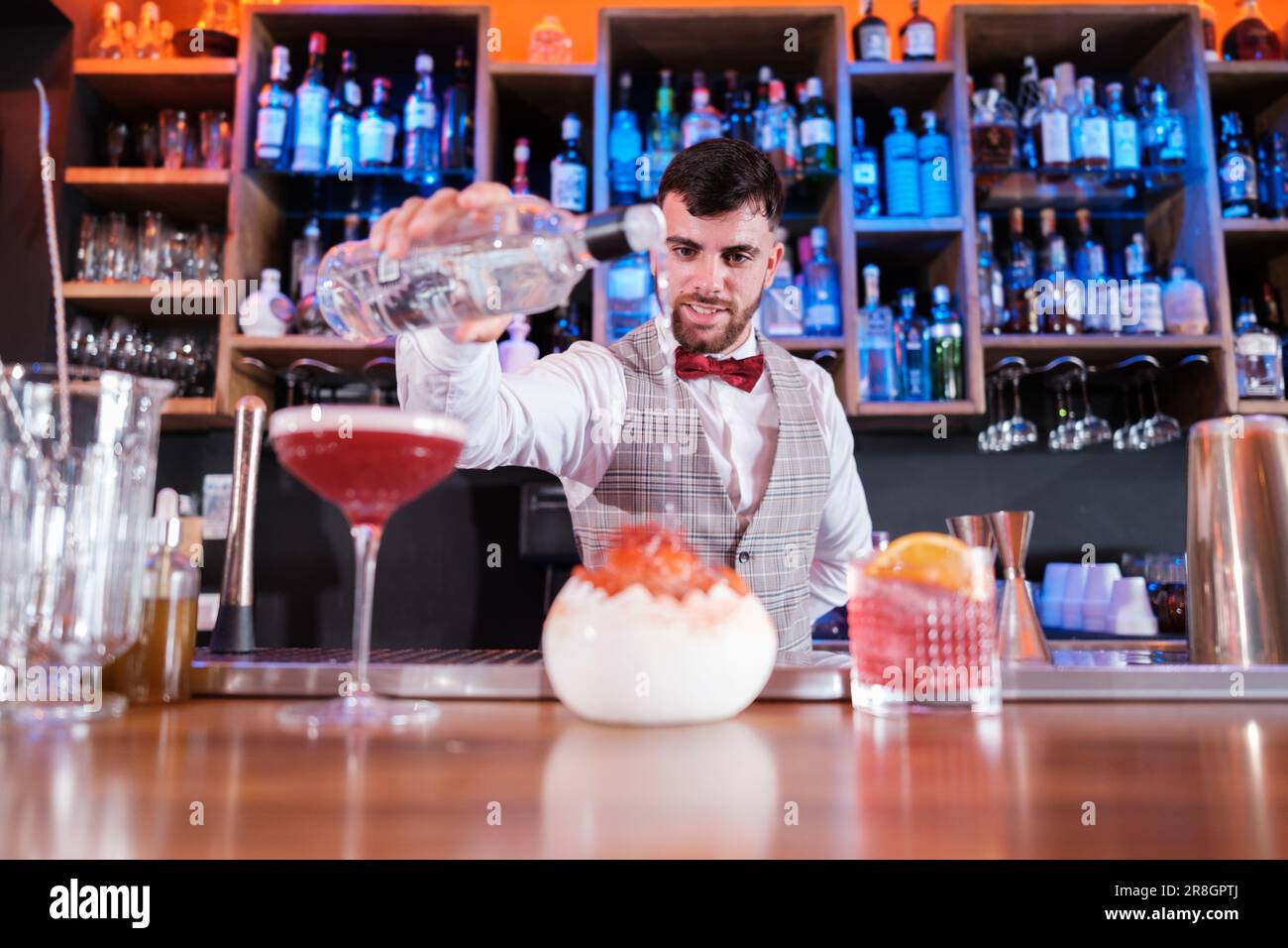 Young cocktail bartender making a special cocktail for his clients ...