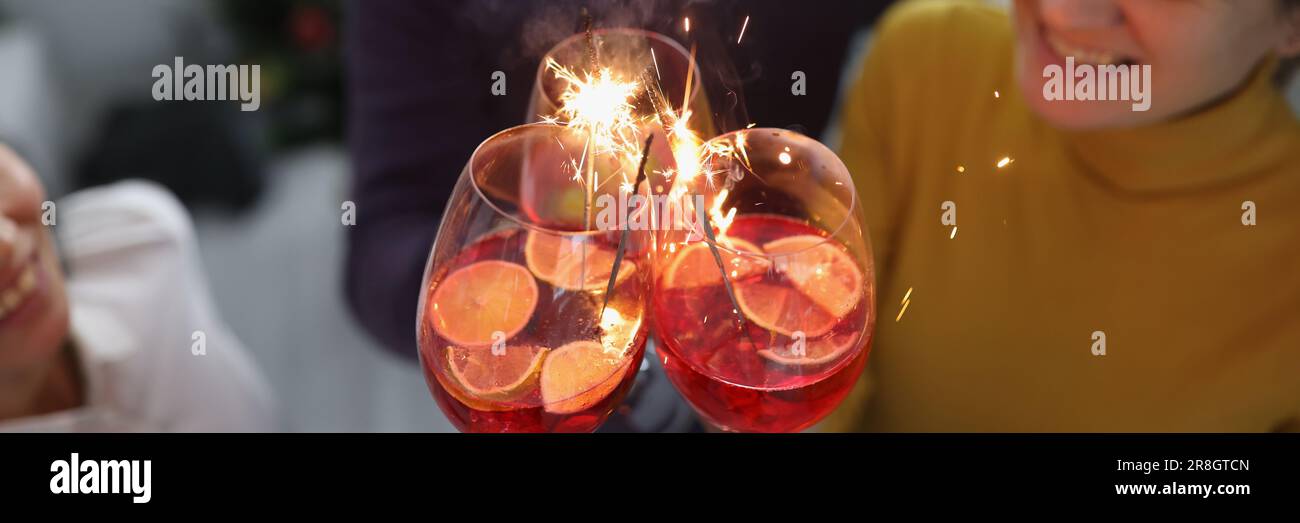 Group of happy people enjoying fireworks party in cocktail glasses ...