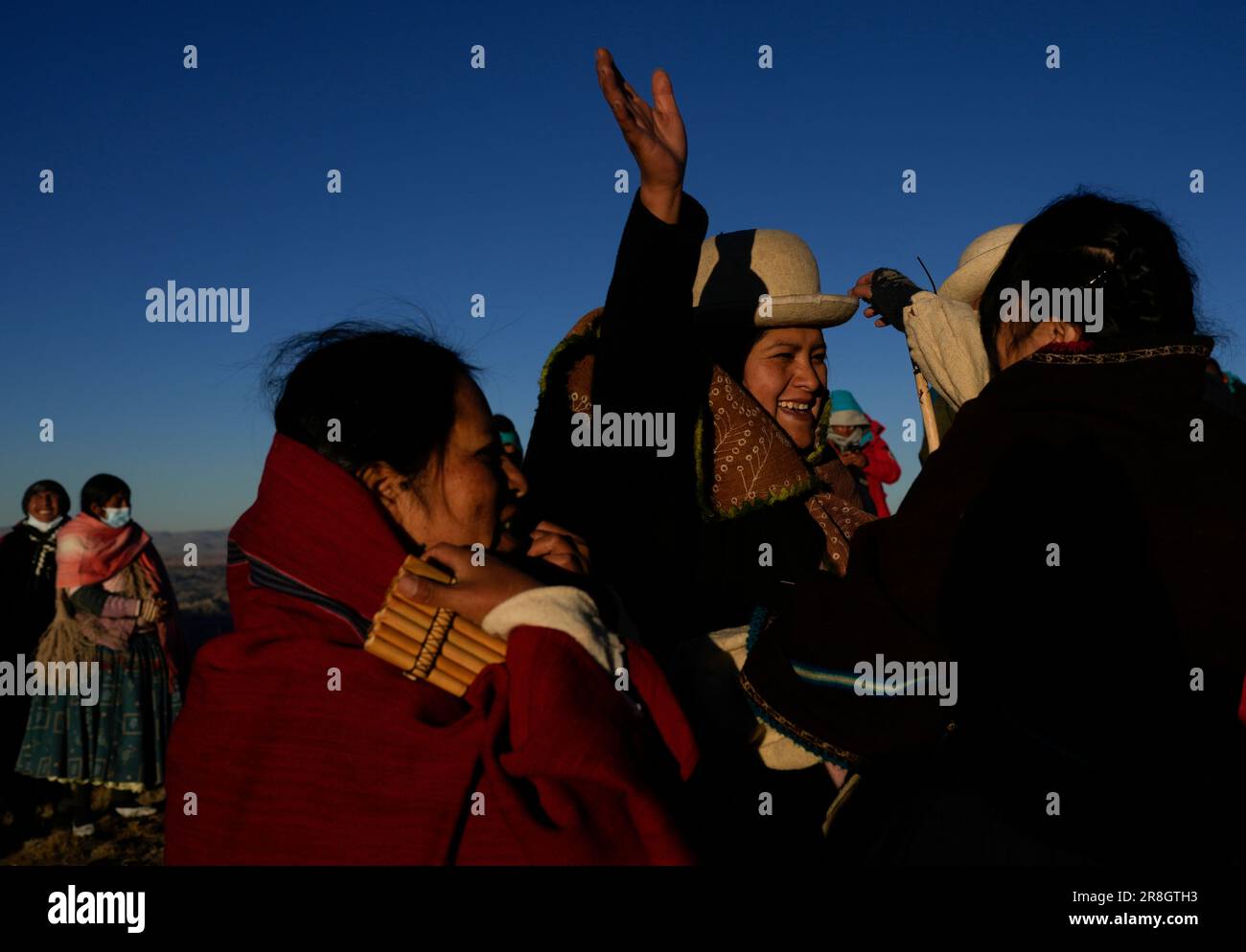 Aymara women embrace after receiving the first rays of sunlight in a ...