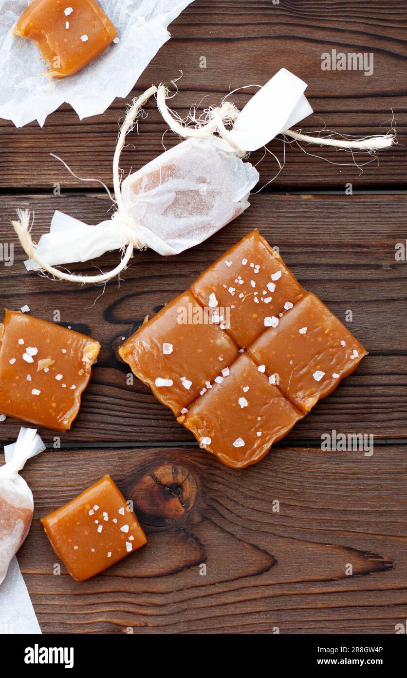 Salted caramel toffee candies with sea salt flakes on rustic wooden ...