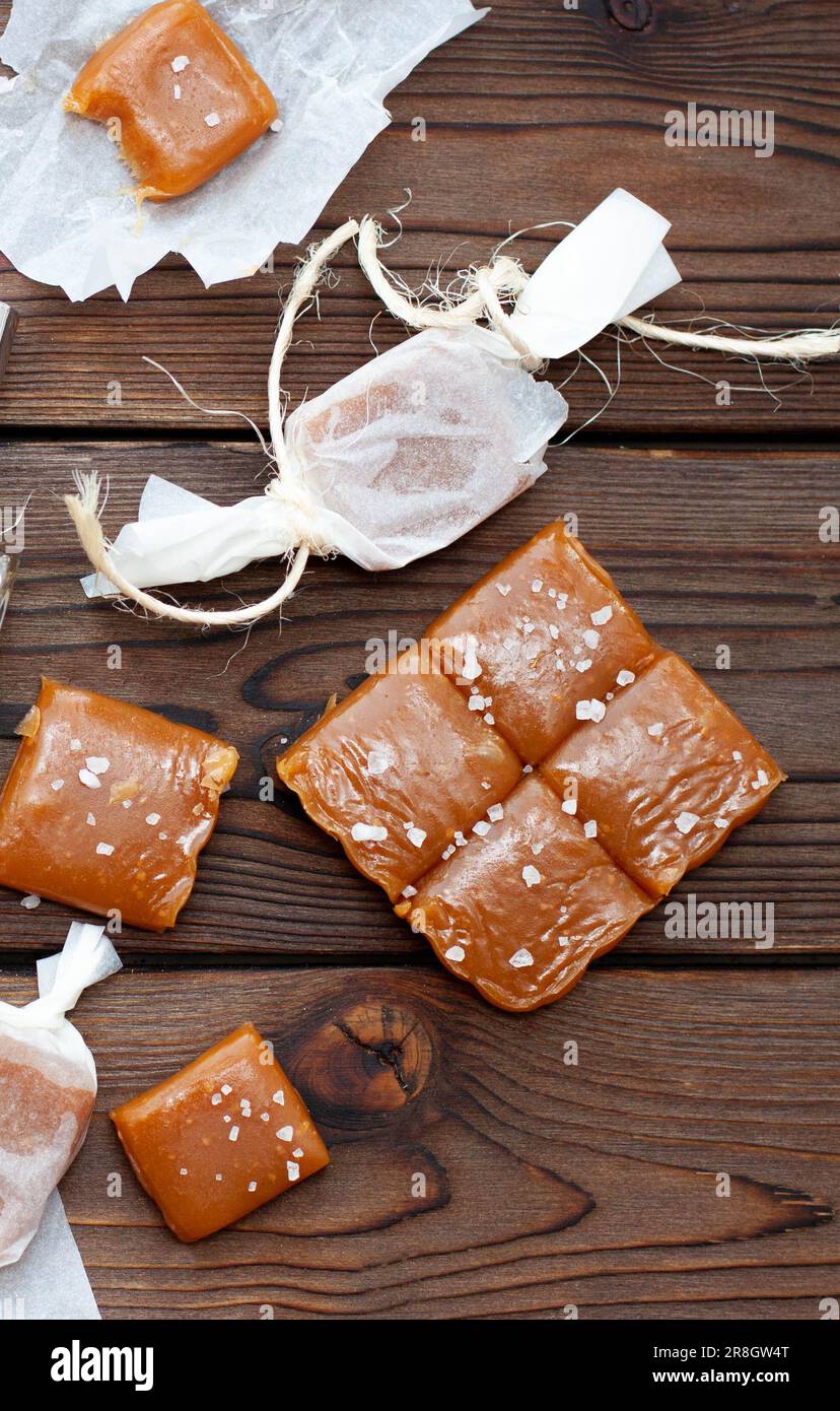 Salted caramel toffee candies with sea salt flakes on rustic wooden ...