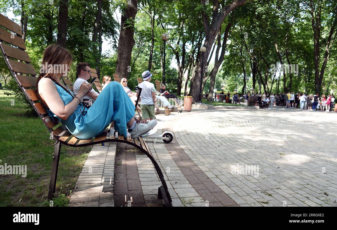 Kyiv, Ukraine June 17, 2023: People sit on a bench in the summer park ...