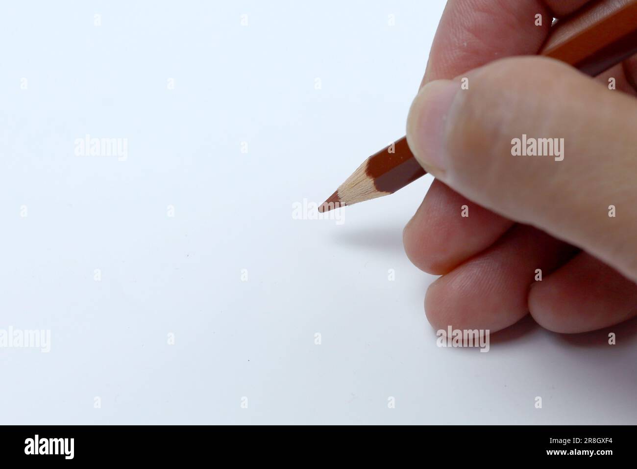 The right hand is drawing with pencil color. Isolated on white ...