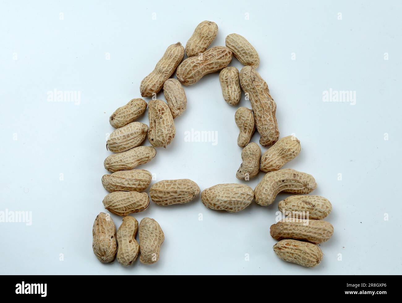 Bunch peanuts form letter A on white background Stock Photo - Alamy