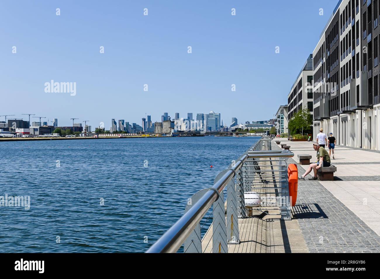 People sitting on bench enjoy the view of dock on a sunny day at Royal ...