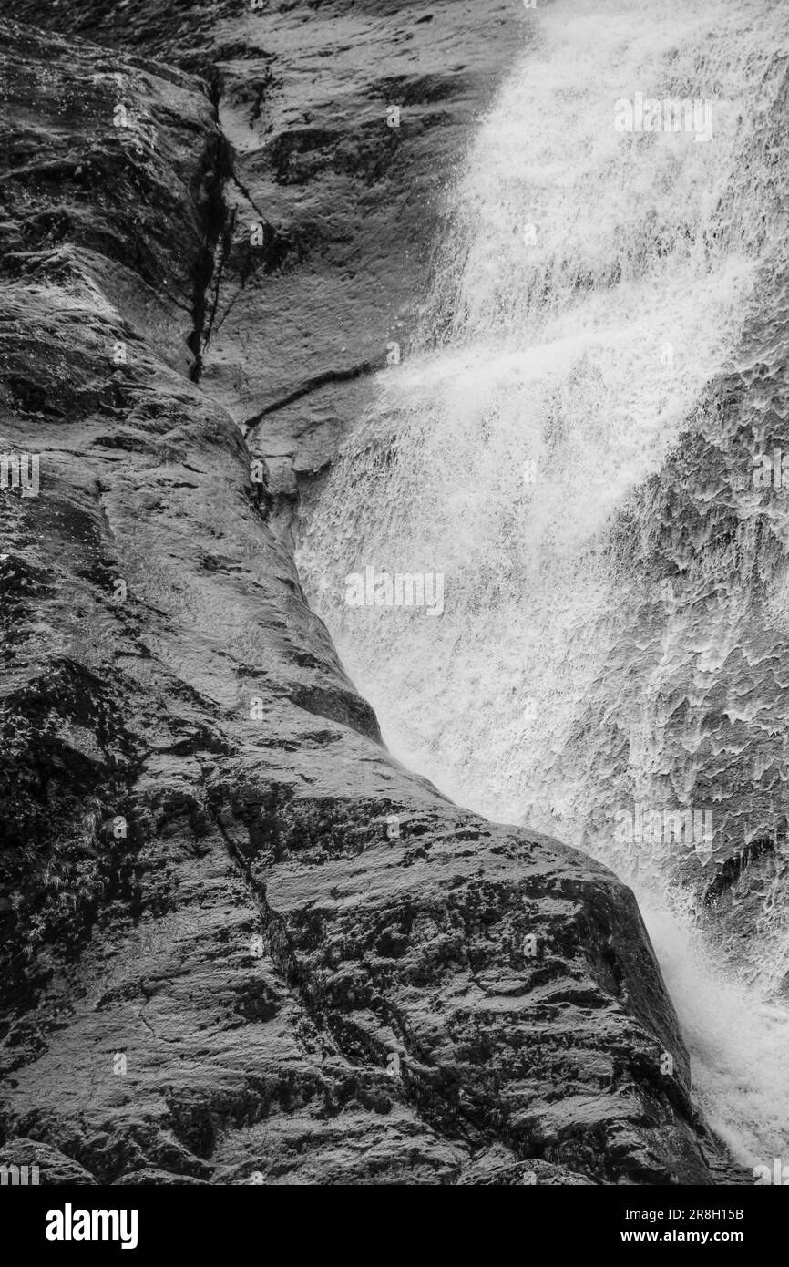 Water cascades down rock face in Alaska in black and white Stock Photo ...