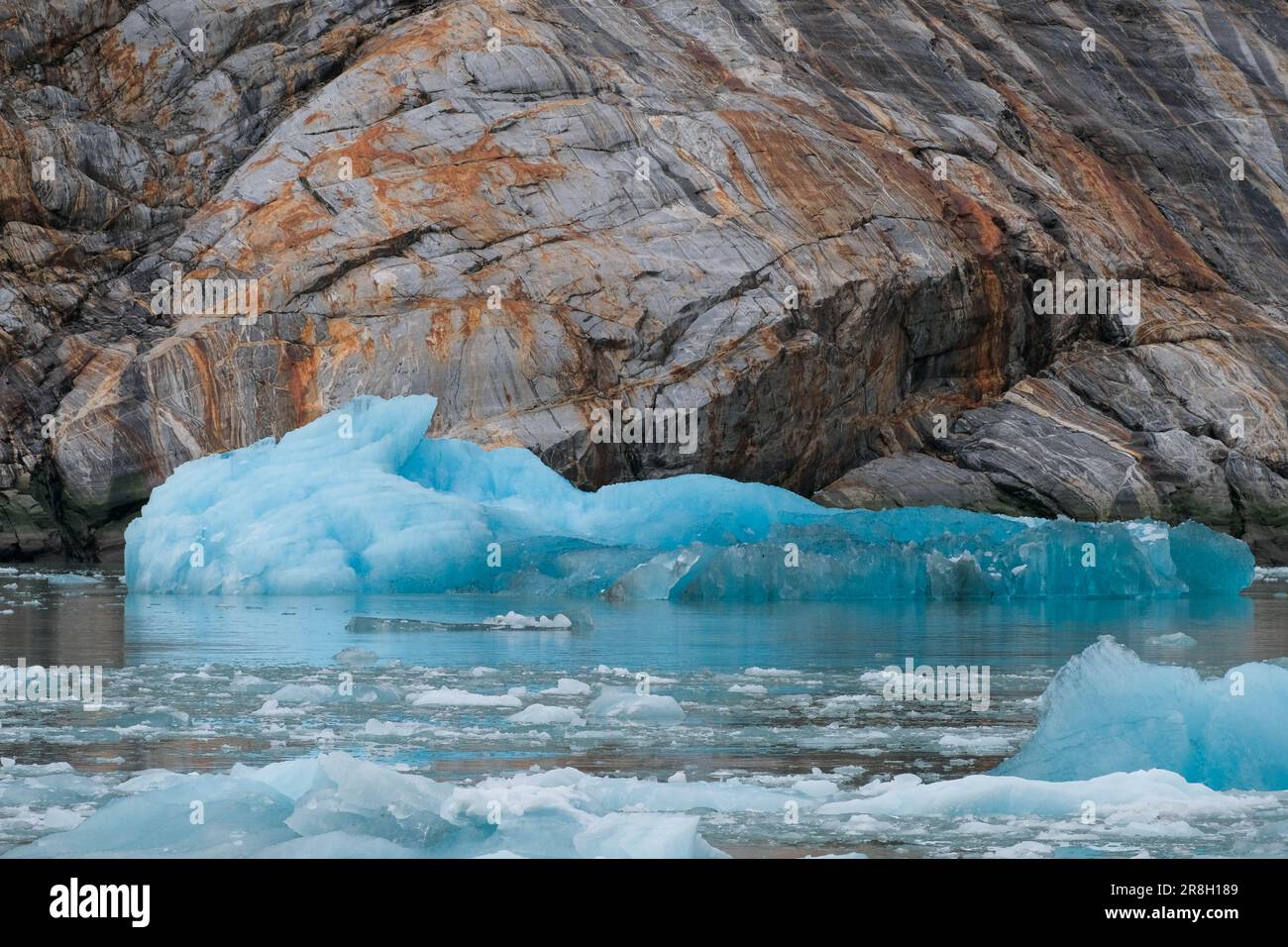 Floating ice and weathered, eroded rock face in Alaska Stock Photo - Alamy