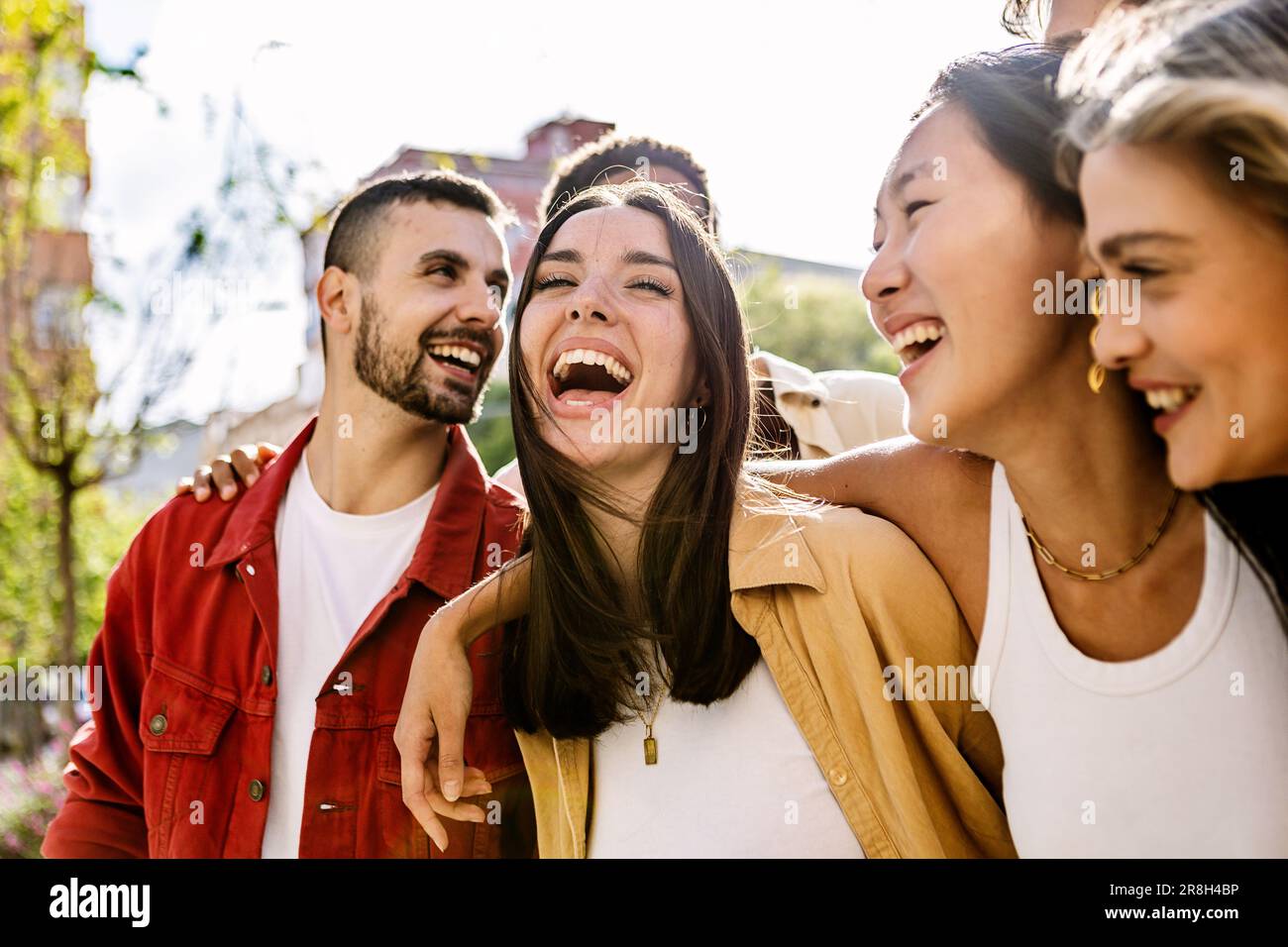 Diverse group of young friends having fun together outdoors in summer ...
