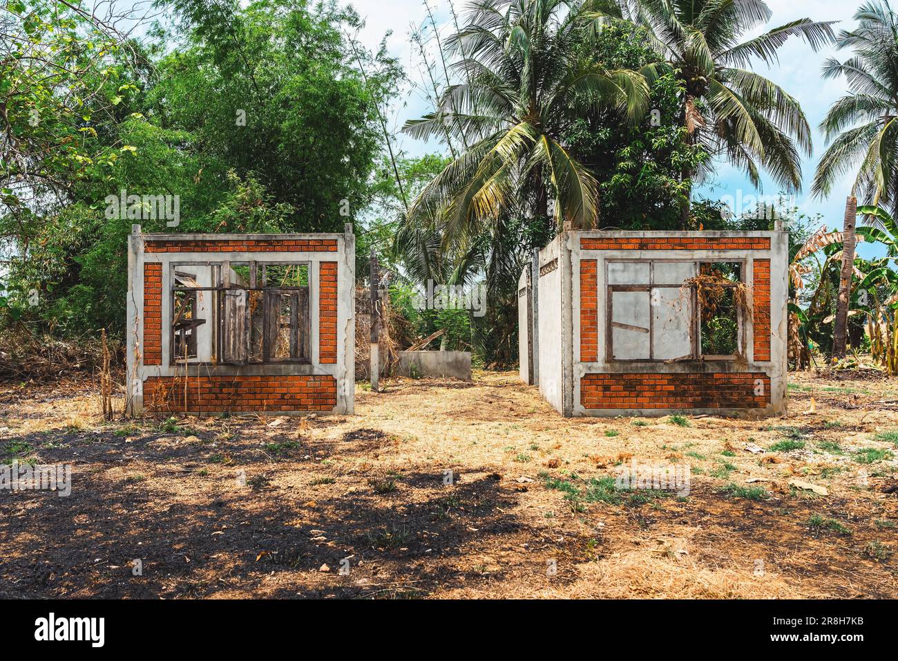 Exterior of old abandoned brick house with broken doors and windows. An ...