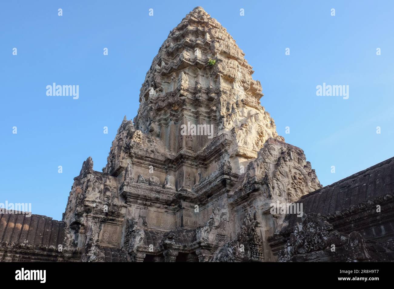 Angkor Wat stone tower under vibrant blue sky Stock Photo - Alamy
