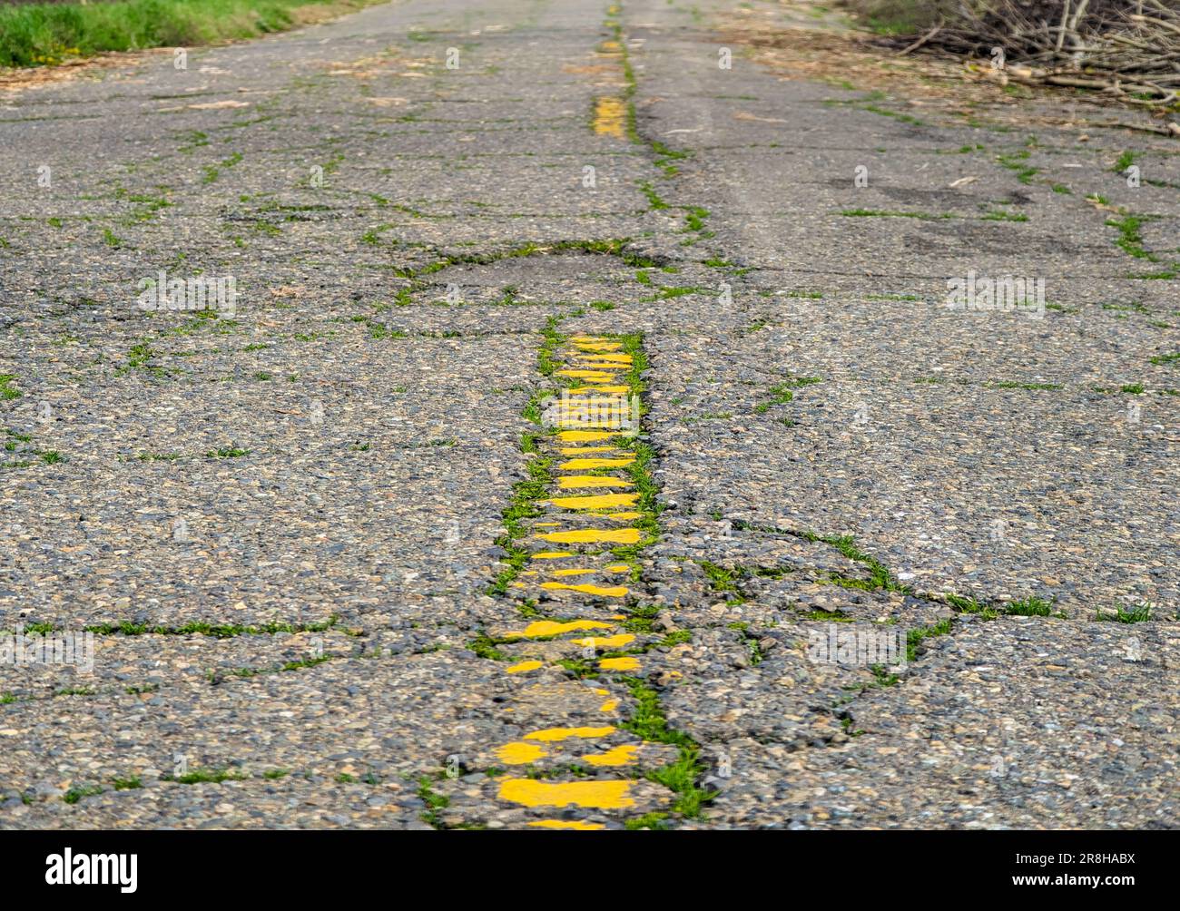 This stock photo features an old country road with a yellow line ...