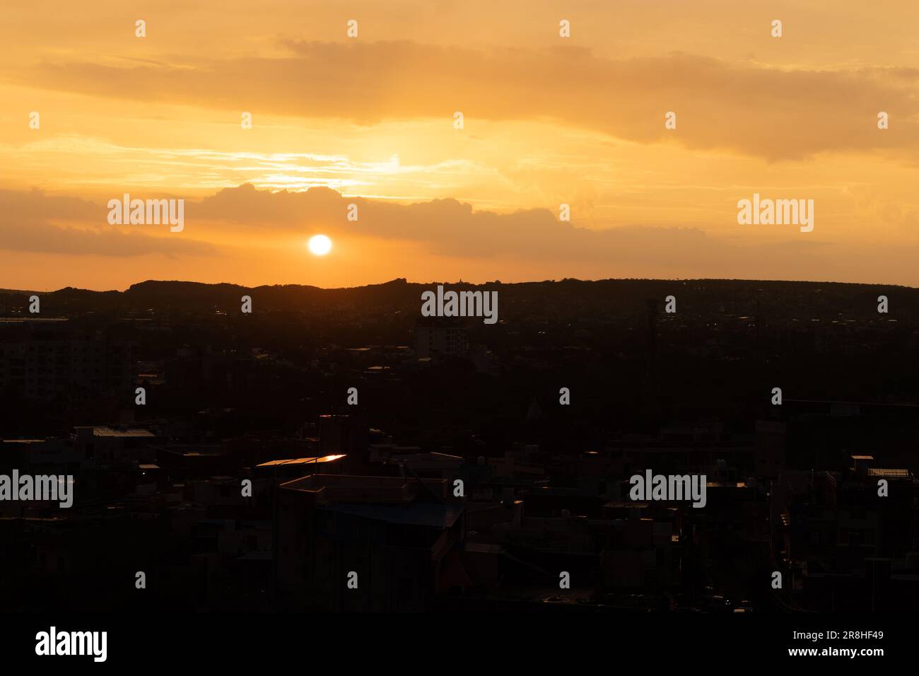 dramatic sunset orange sky with city backlit view from mountain top at ...