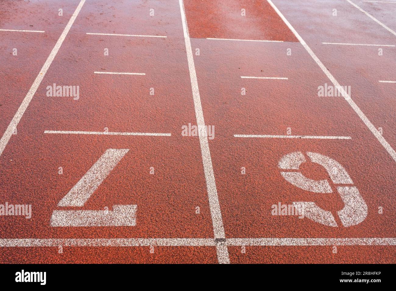 A close-up of a running track with white markings in the center ...