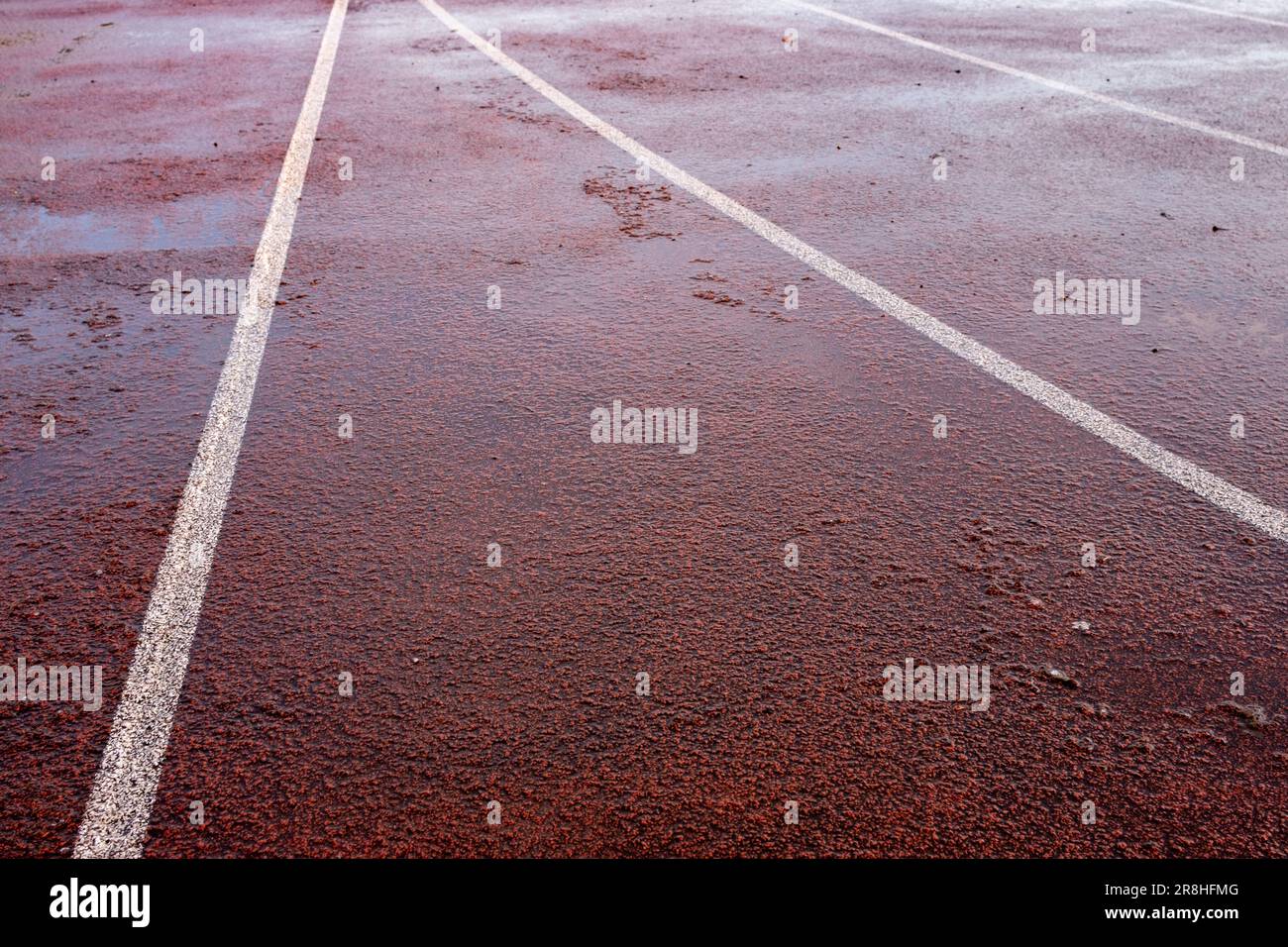 An empty parking lot with wet tracks running through it, illuminated by ...
