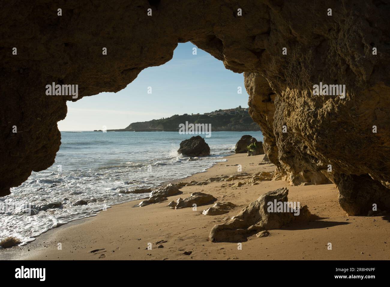 A scenic view of a beachside cave entrance looking out onto the serene ...