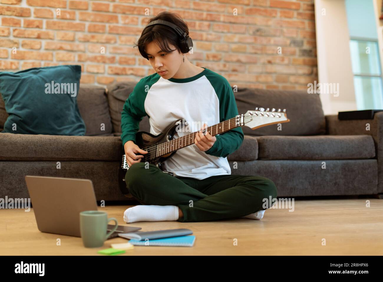 Asian Teenager Guy Learning Guitar Online Via Laptop At Home Stock ...