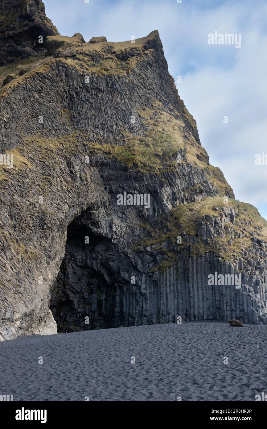Mountain with a cave, located on a beach. Fascinating structure of the ...