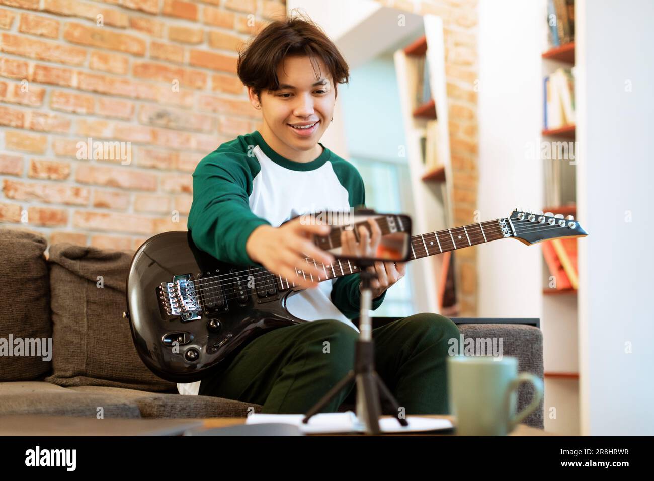 Chinese Teen Boy Records Guitar Session On Phone At Home Stock Photo ...
