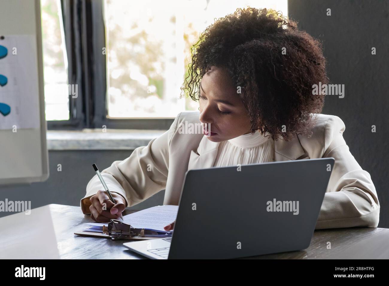 Black young woman secretary taking notes at modern office Stock Photo ...