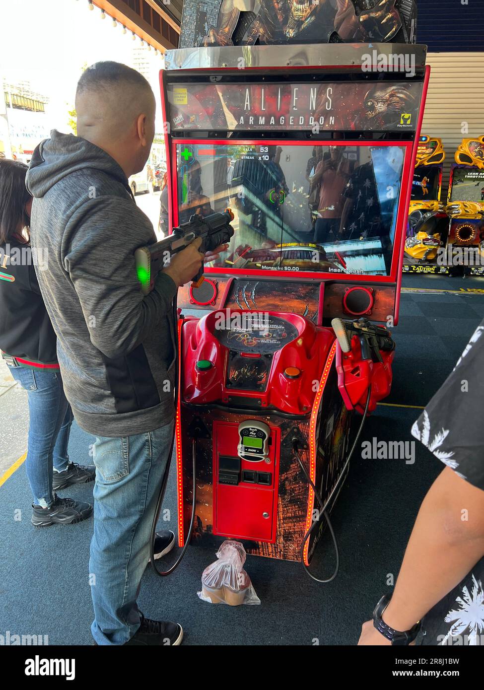 Man plays violent video game at an arcade at COney Island at the beach ...