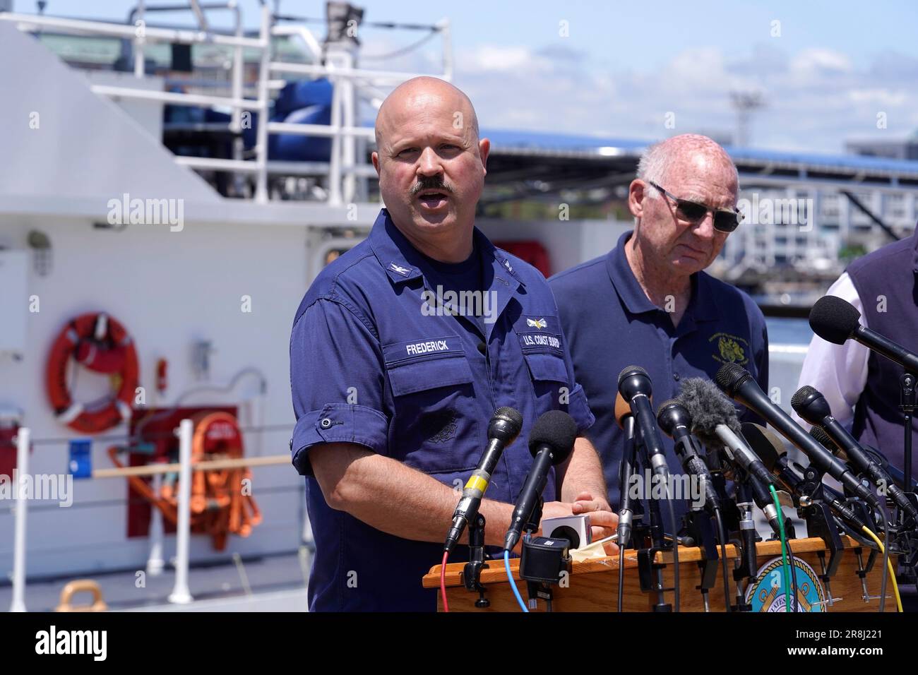 U.S. Coast Guard Capt. Jamie Frederick, left, faces reporters as Paul ...