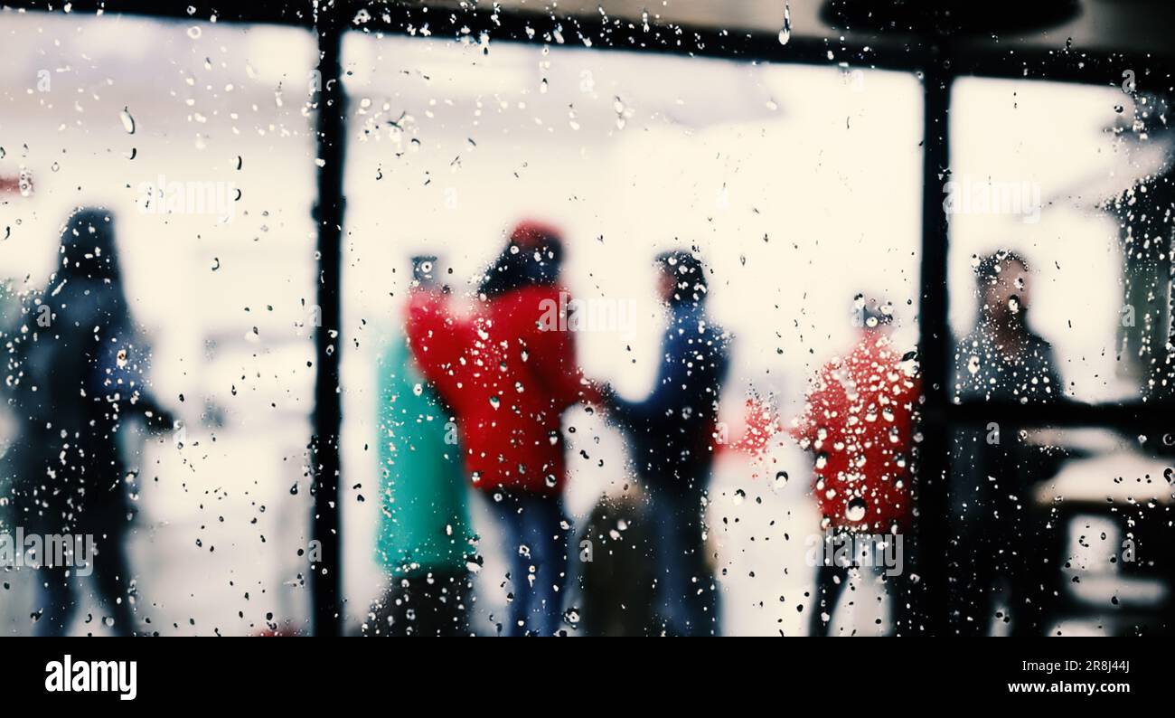 Rain drop on window glass of coffee shop and blurry city life ...