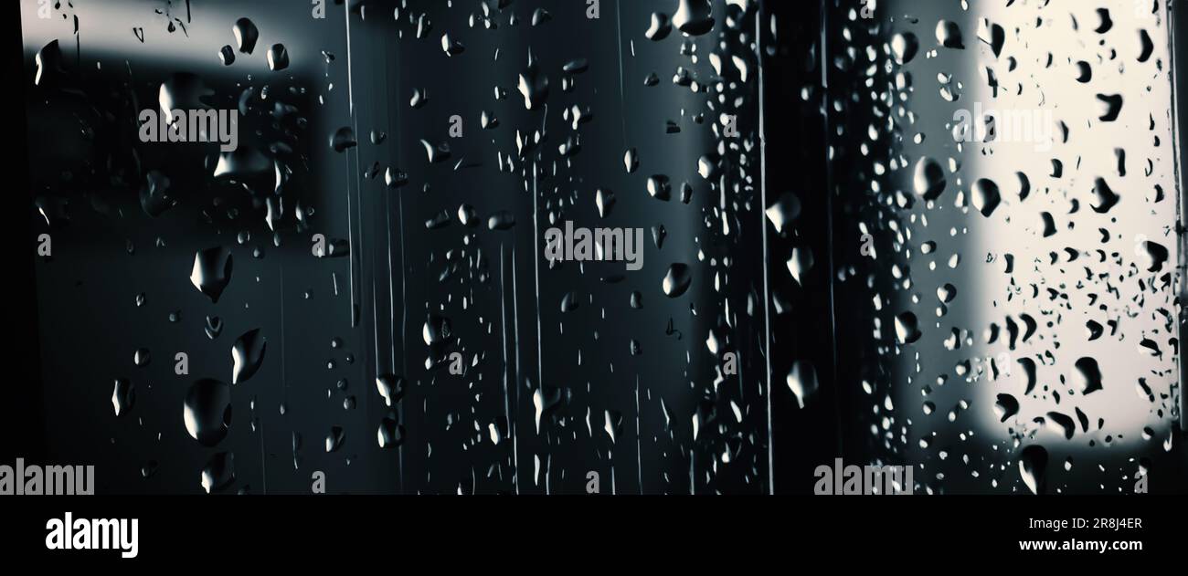 Rain drop on window glass of coffee shop and blurry city life ...