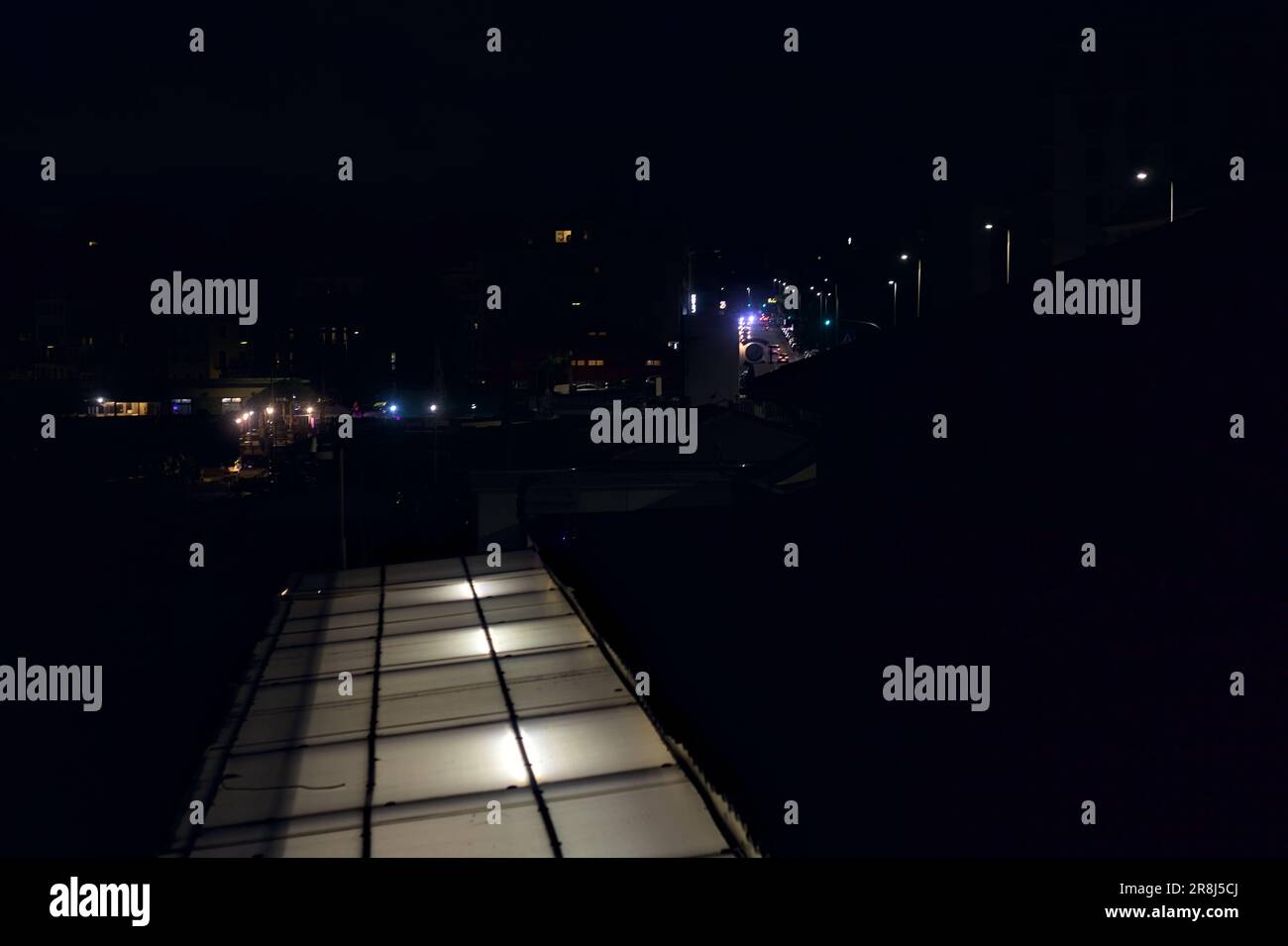 Town on a cliff by the sea at night seen from a beach afar Stock Photo ...