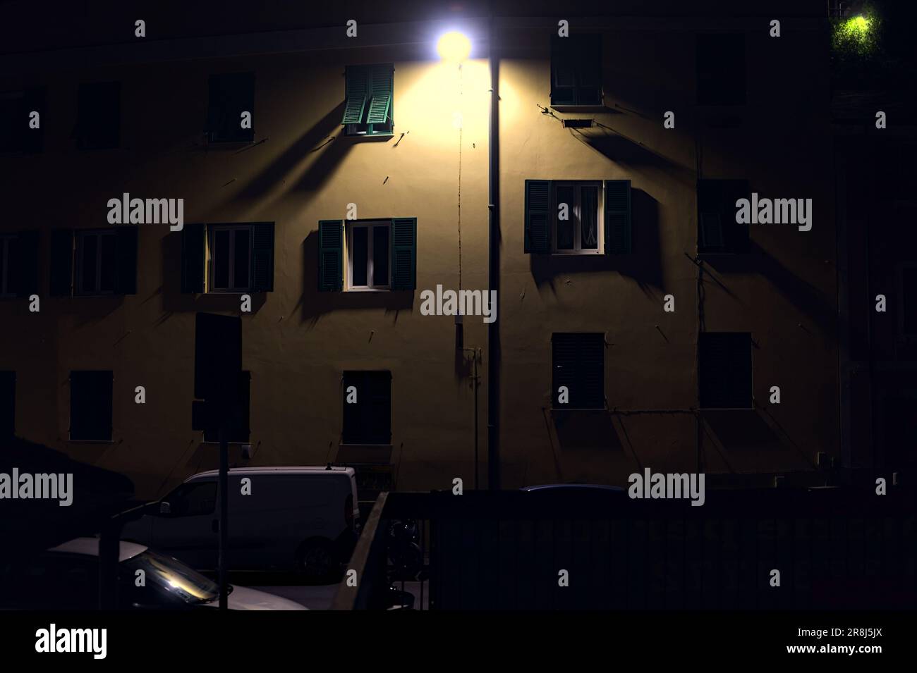 Facade of a building with closed shutters at night in an italian city ...