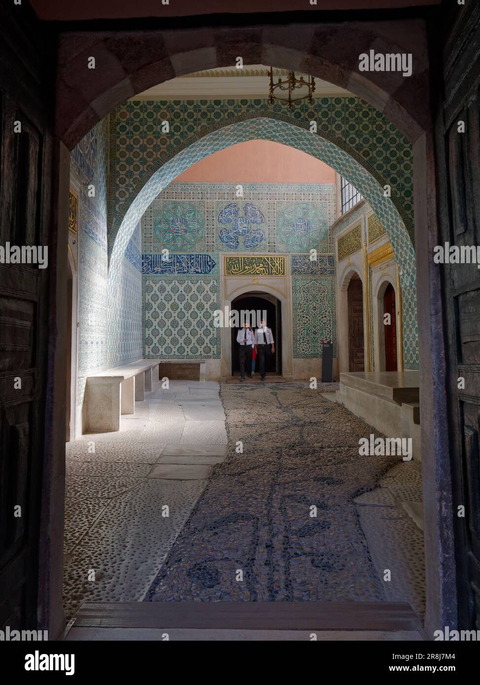 Officials walk in a beautifully elegant room with blue tiles and stone ...