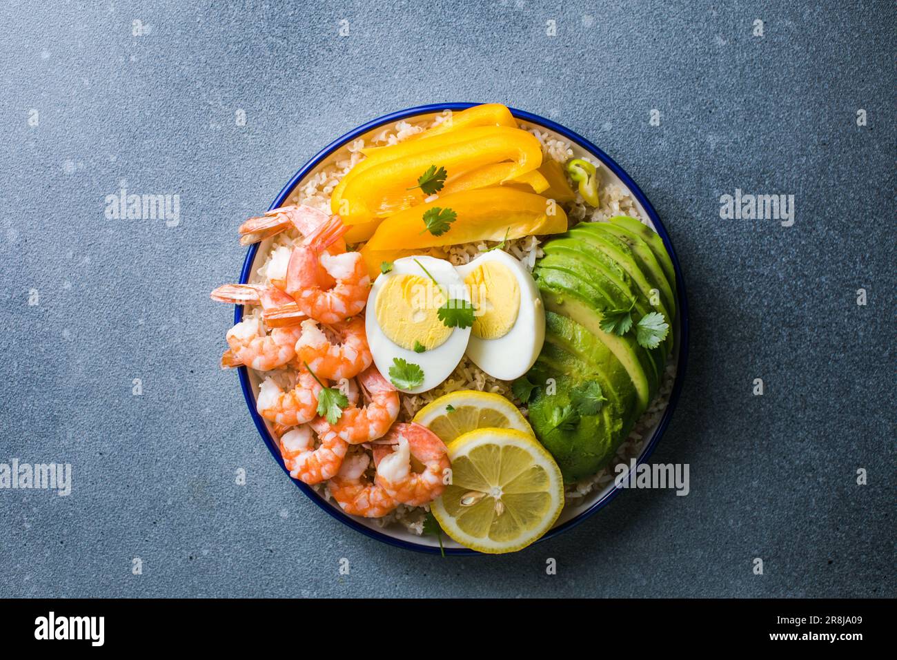 tropical bowl with avocado, prawns, rice, on light background. Healthy ...
