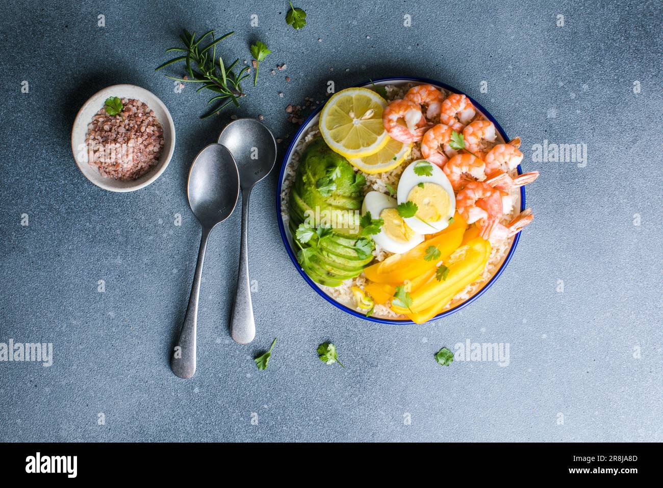 tropical bowl with avocado, prawns, rice, on light background. Healthy ...