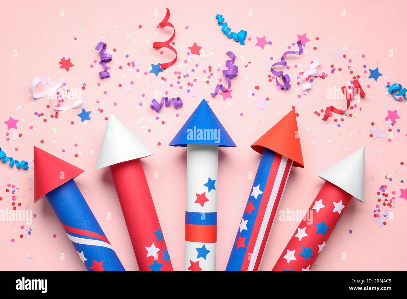 Firework rockets, confetti and serpentine for Independence Day on pink ...