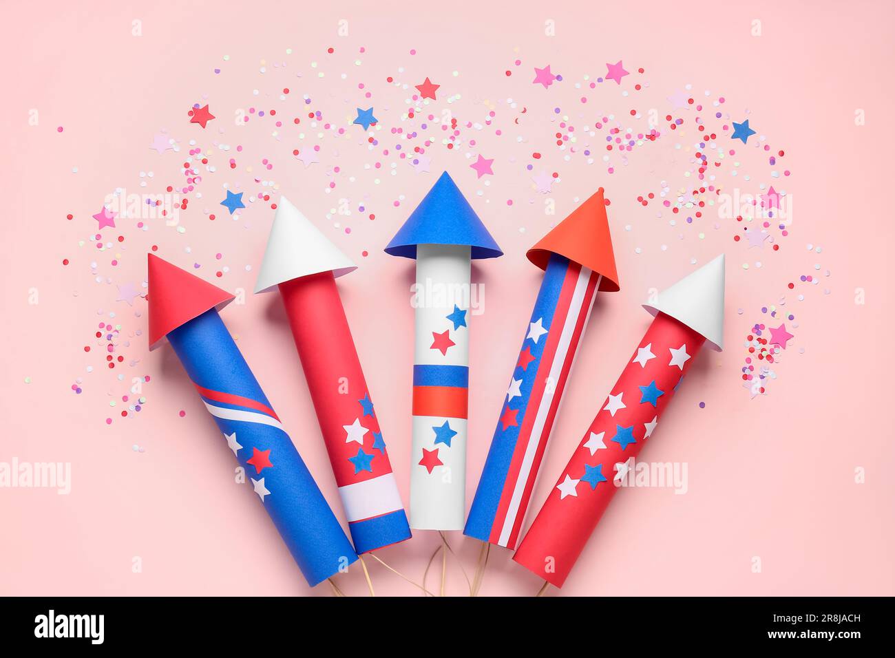 Firework rockets, confetti and serpentine for Independence Day on pink ...