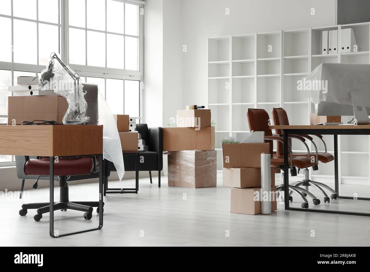 Workplaces with cardboard boxes in office on moving day Stock Photo - Alamy