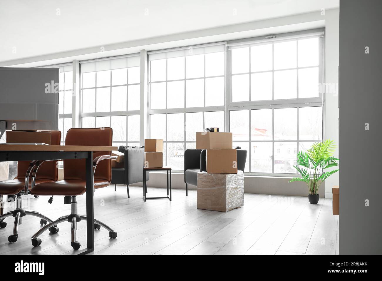 Workplaces with cardboard boxes in office on moving day Stock Photo - Alamy