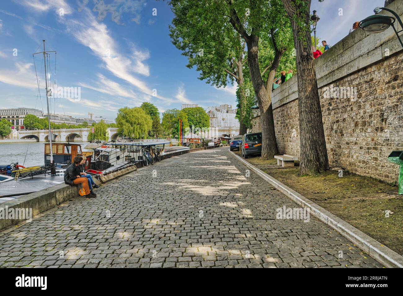 A tranquil riverbank of the River Seine in Paris, France, featuring a ...