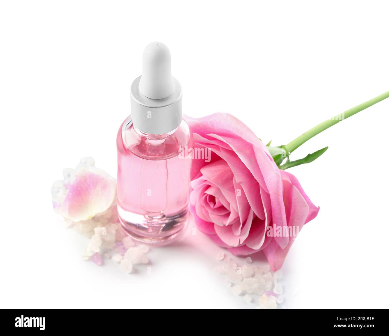 Bottle of cosmetic oil with rose extract and flower on white background ...