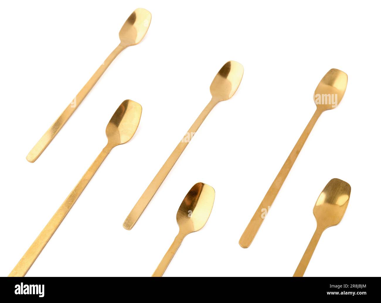 Golden spoons on white background Stock Photo - Alamy