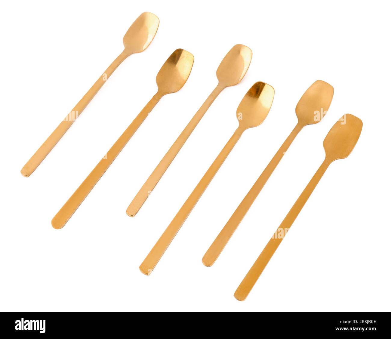 Golden spoons on white background Stock Photo - Alamy