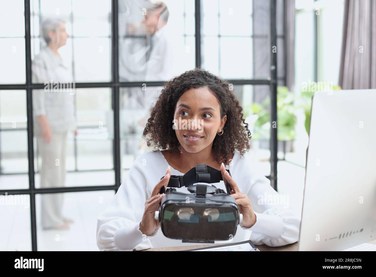 woman testing VR glasses or goggles sitting in the office room Stock ...