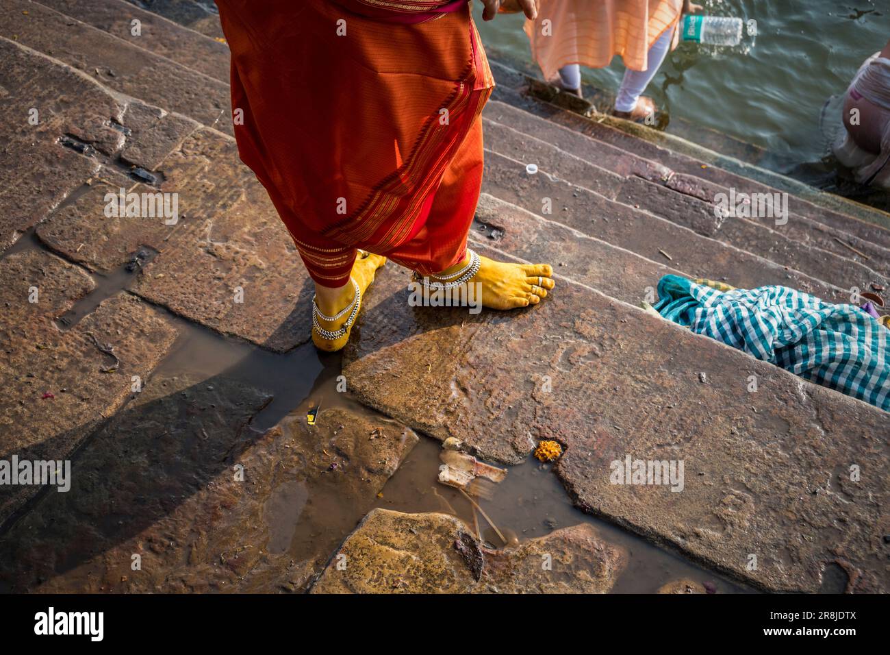 A woman with saffron stained feet on the ghats of Varanasi, India Stock ...